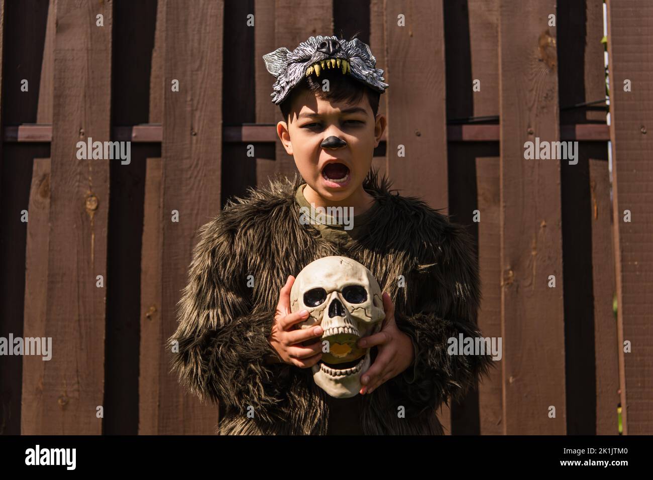 asian kid in werewolf costume growling and holding skull while looking ...