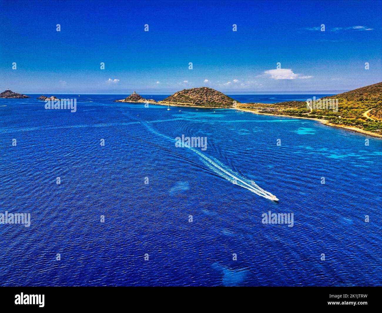 an aerial shot of Corisa beach and small islands with a boat passing by ...