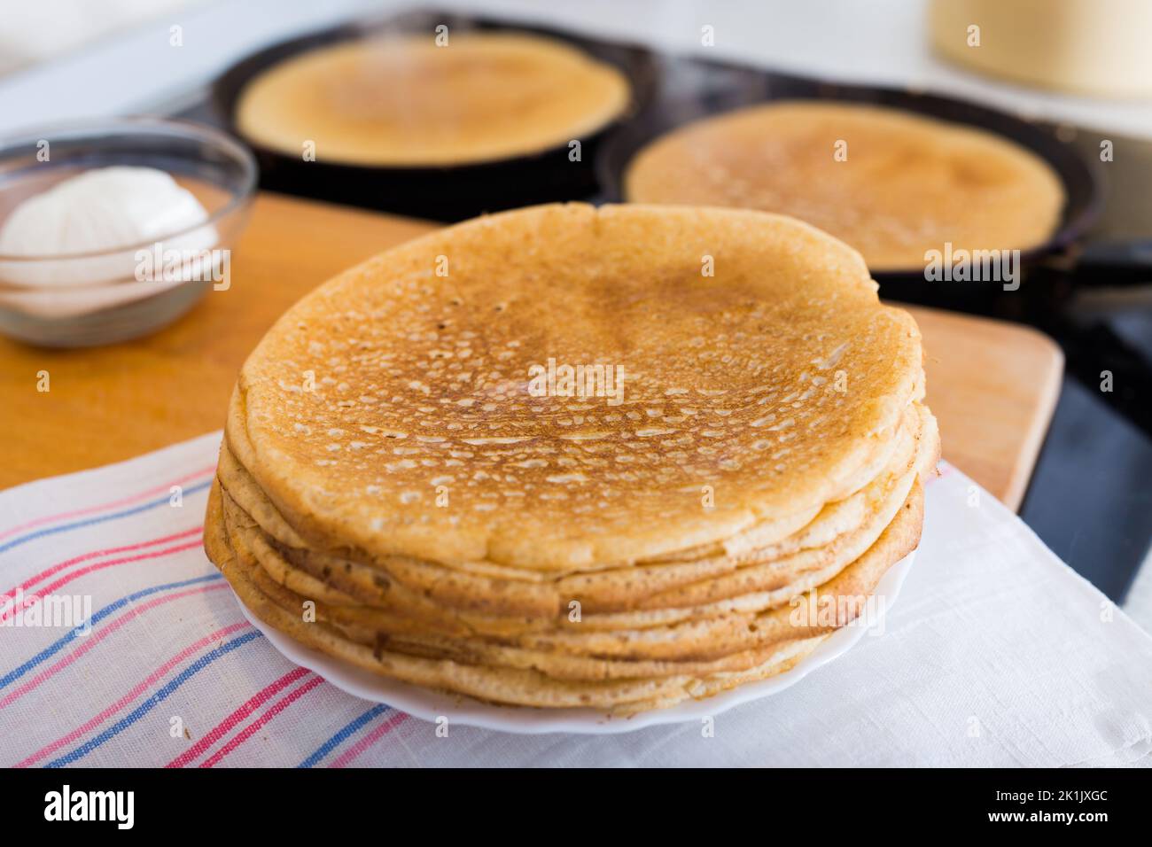 hot golden pancakes made from grain flour in kitchen while cooking on ...