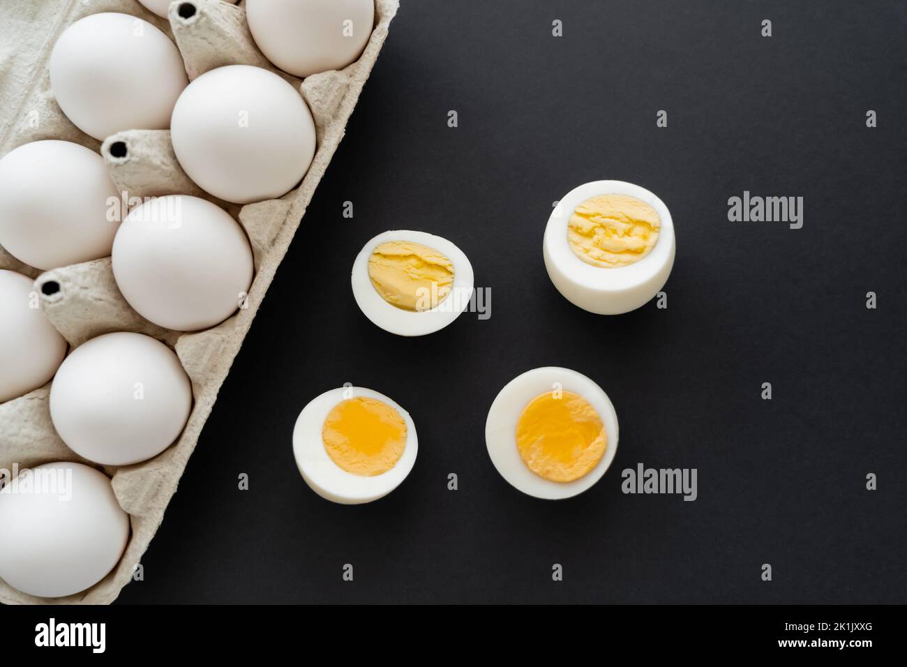 Top view of boiled and raw eggs in cardboard container on black surface Stock Photo - Alamy