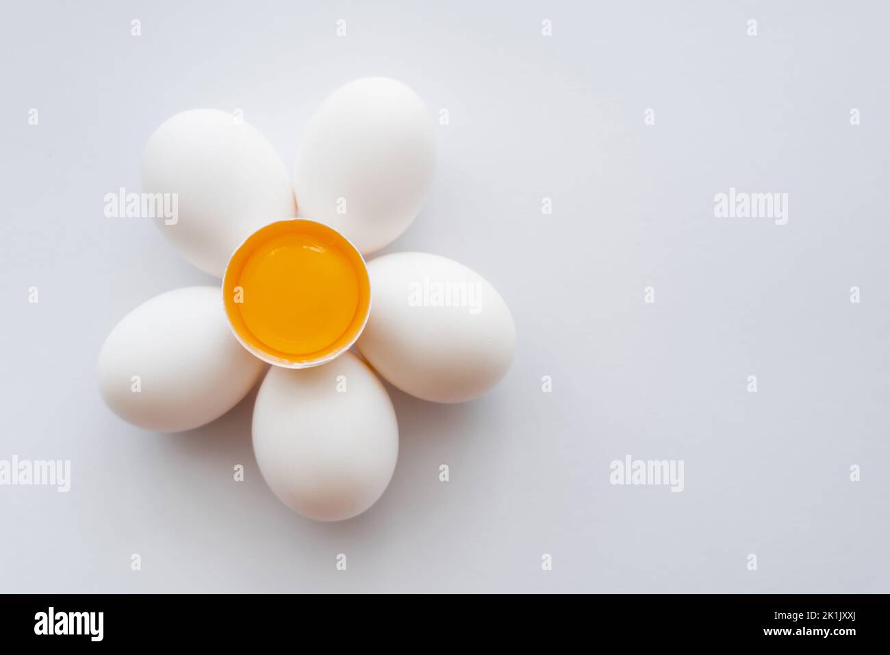 Flat lay with yolk in shell on eggs on white background Stock Photo - Alamy