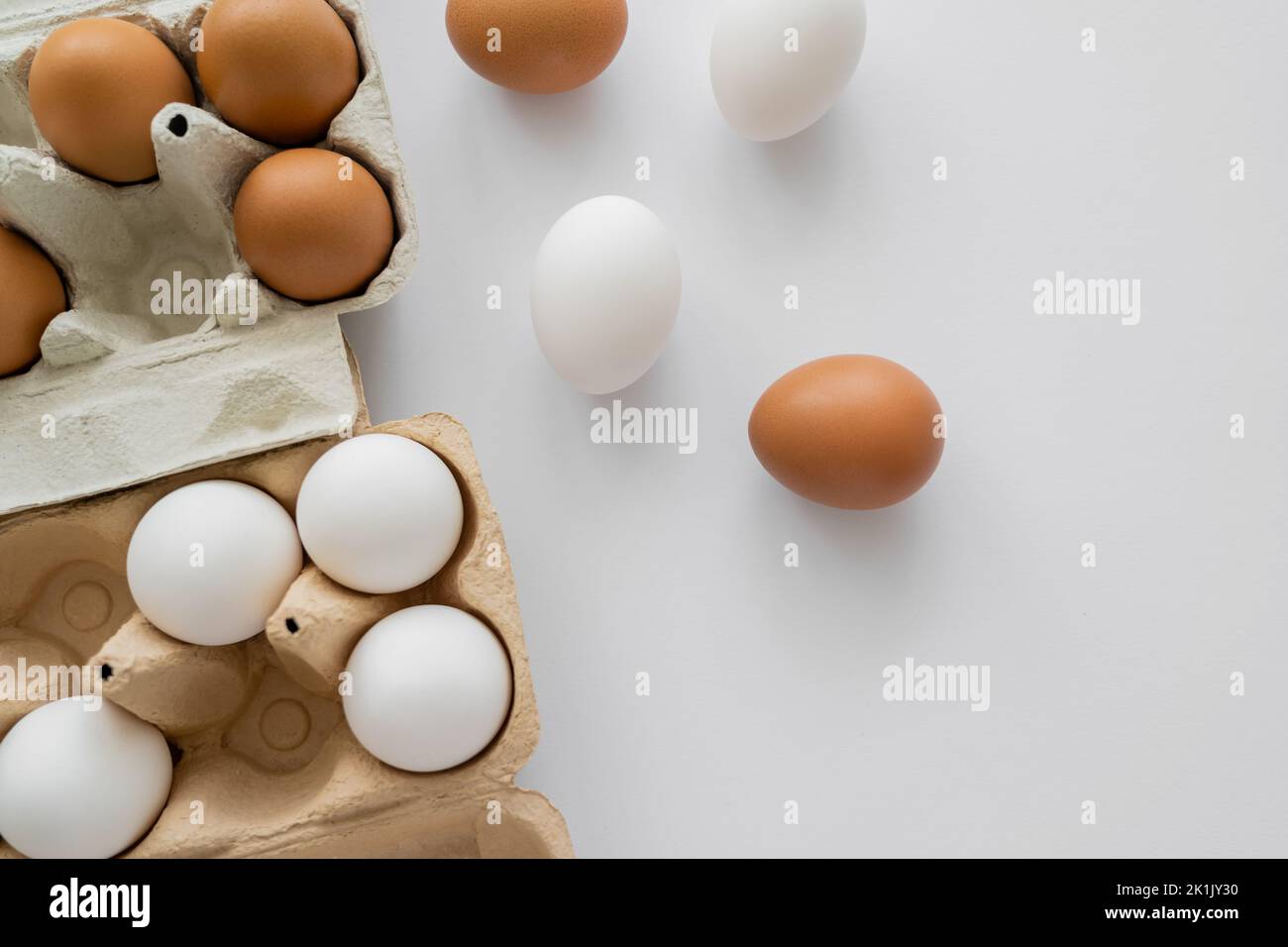 Top view of eggs in shells near carton boxes on white background Stock ...