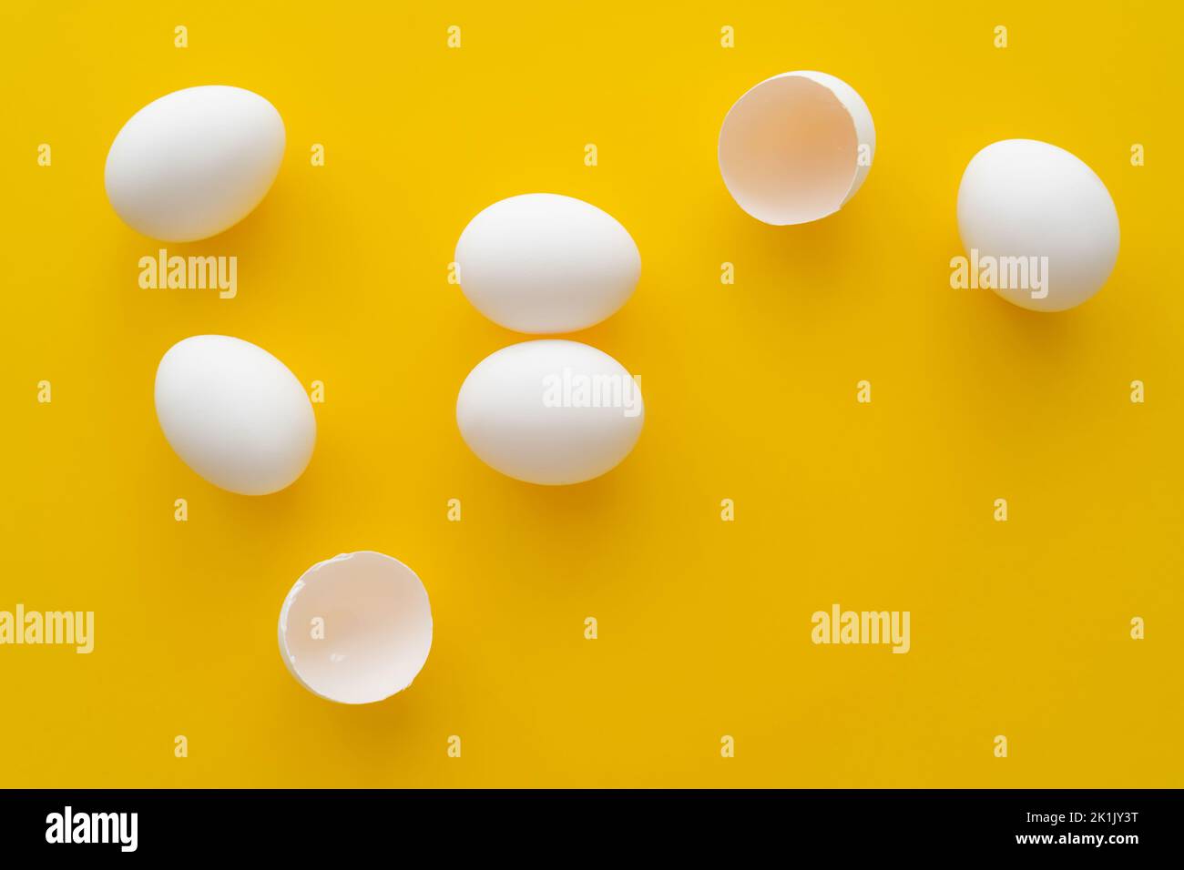 Top view of white eggs and shells on yellow background Stock Photo - Alamy
