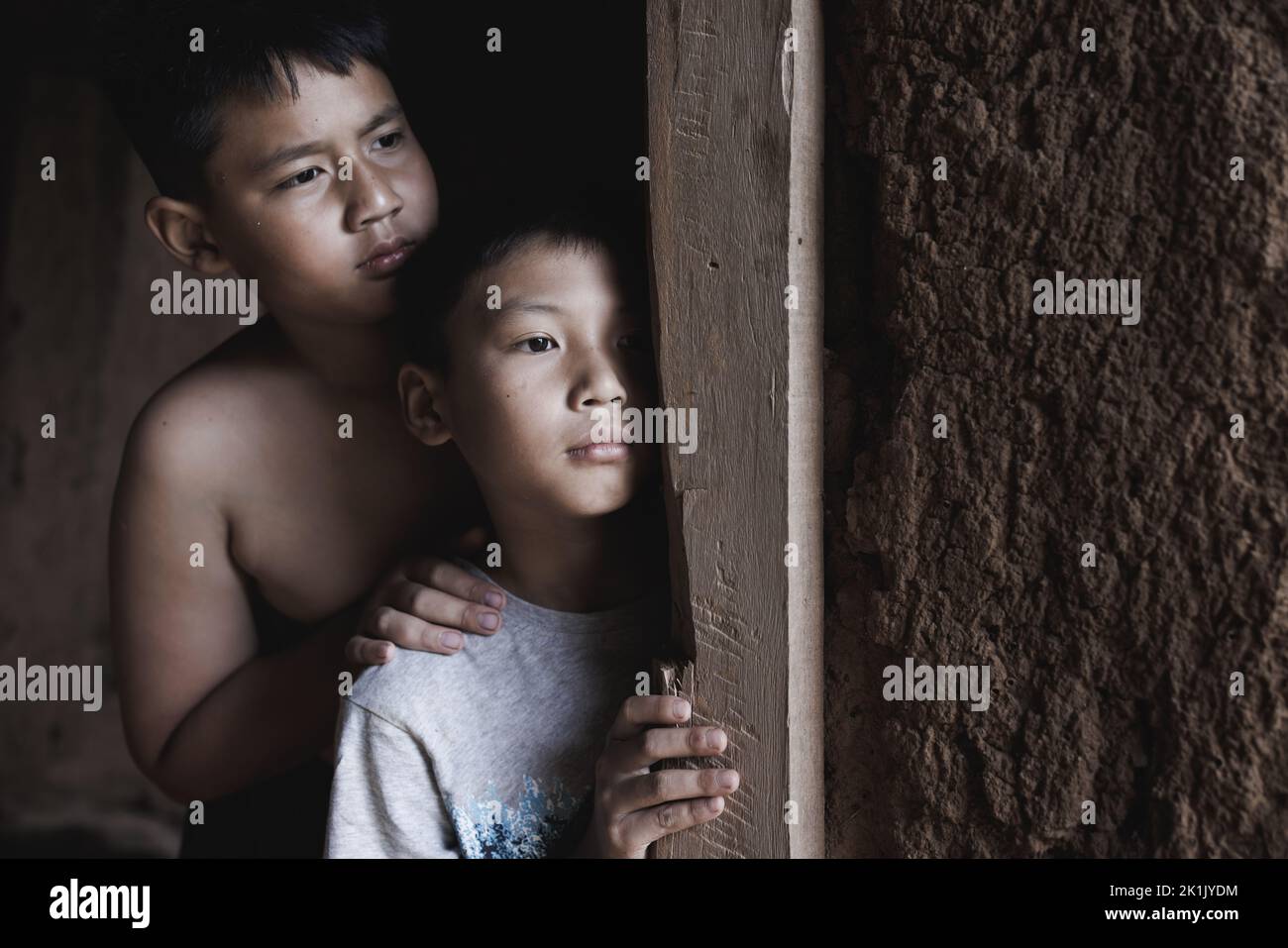 Closeup poor boy peeking out of a dilapidated house, Concept of ...