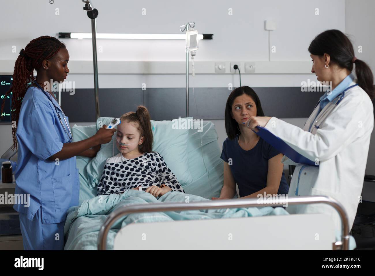 Nurse measuring sick little girl temperature while pediatrist ...