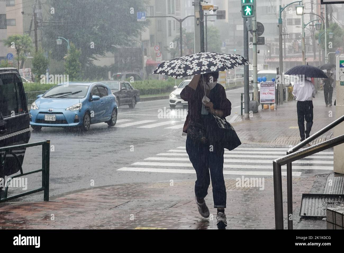 Tokyo, Japan. 19th Sep, 2022. Pedestrians walk in the rain along a ...