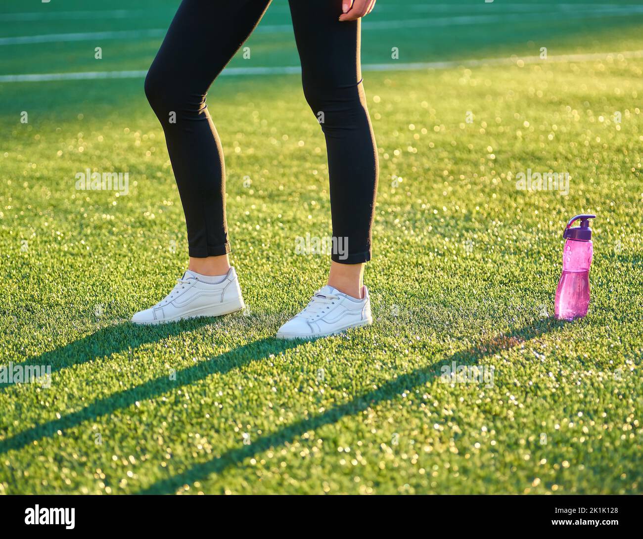 Sports girl doing stretching on the stadium lawn Stock Photo - Alamy