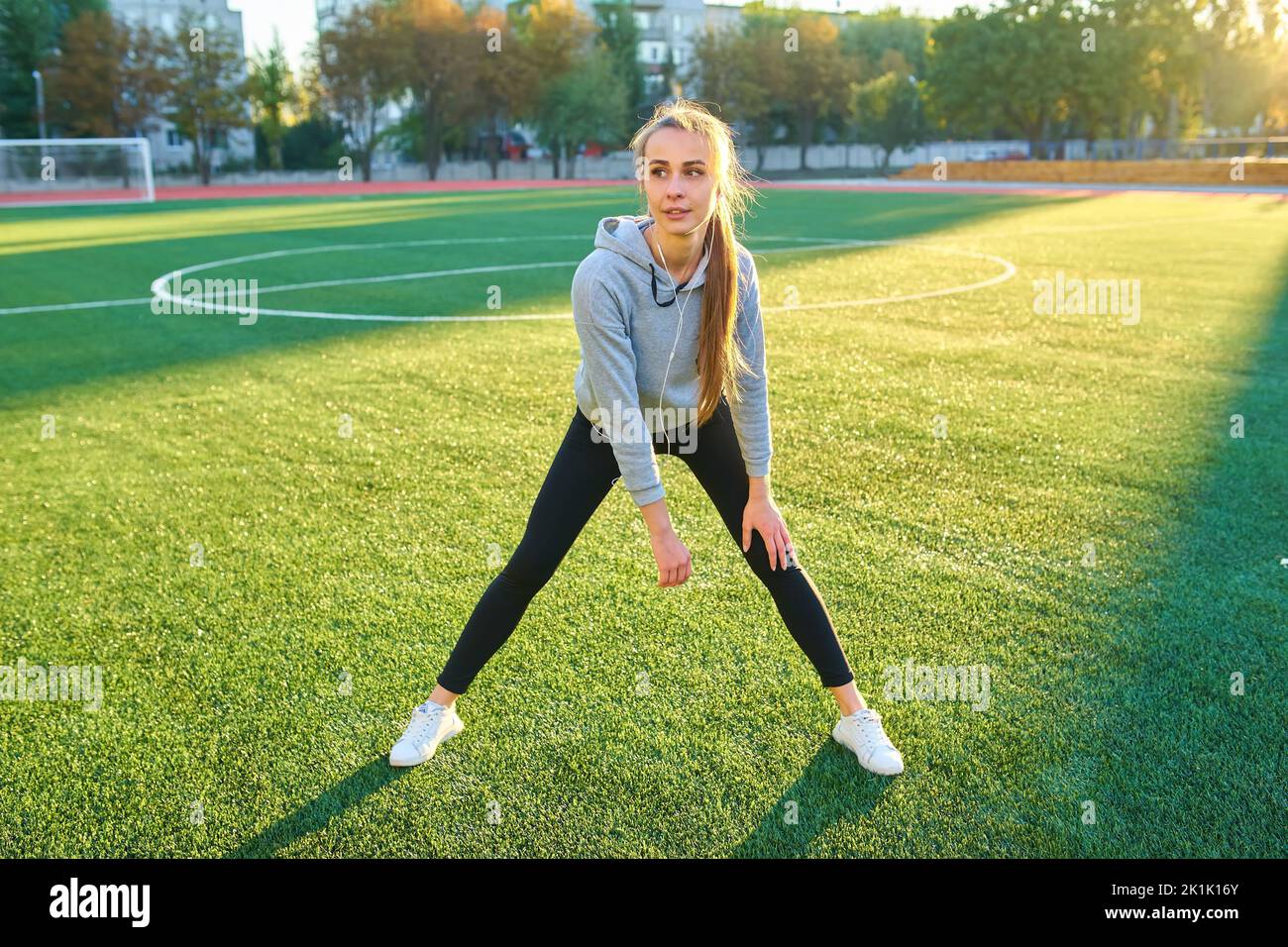 Sports girl doing stretching on the stadium lawn Stock Photo - Alamy