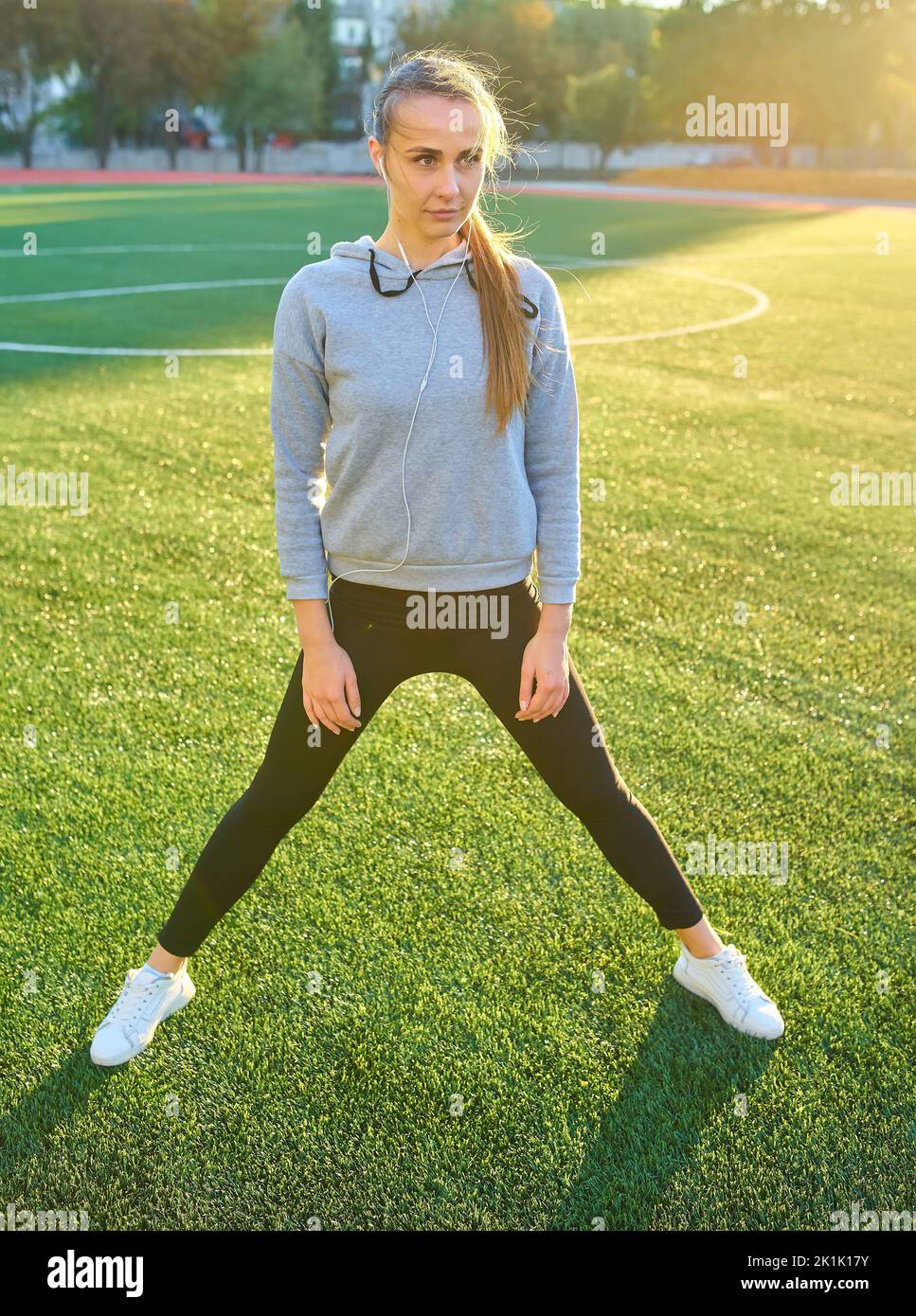 Sports girl doing stretching on the stadium lawn Stock Photo - Alamy