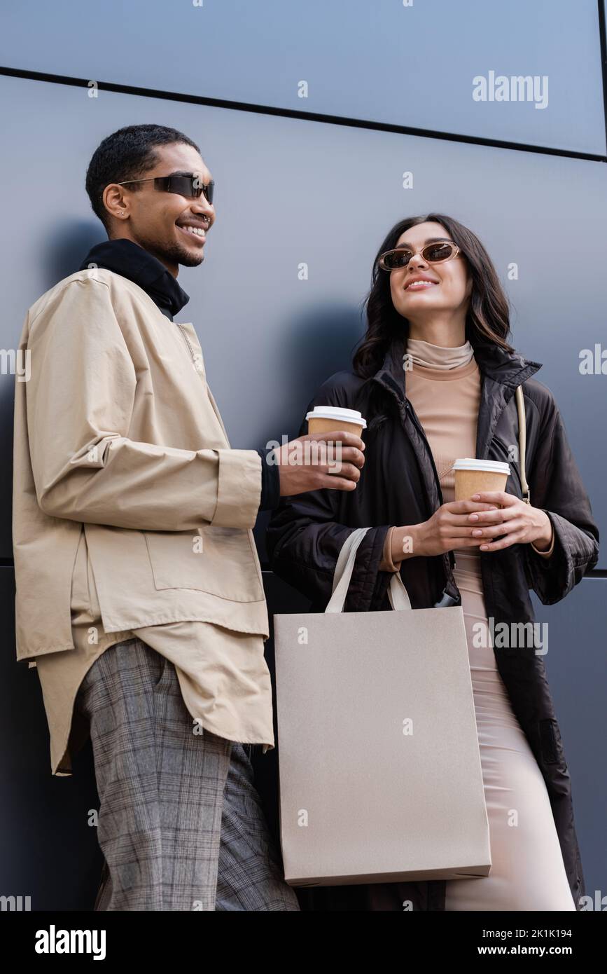 happy african american man and young woman in stylish sunglasses ...