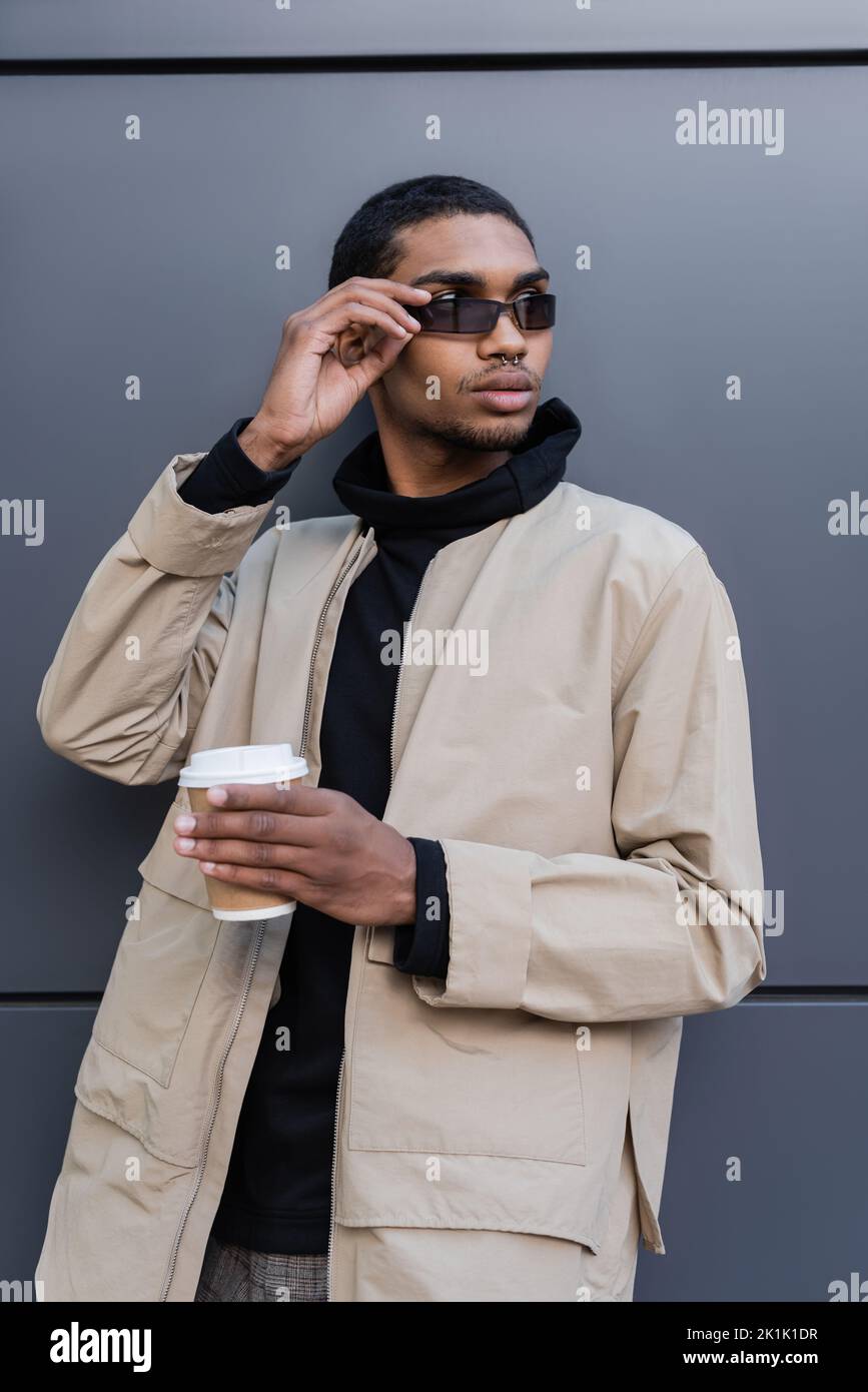 stylish african american man in autumnal outfit holding paper cup and ...