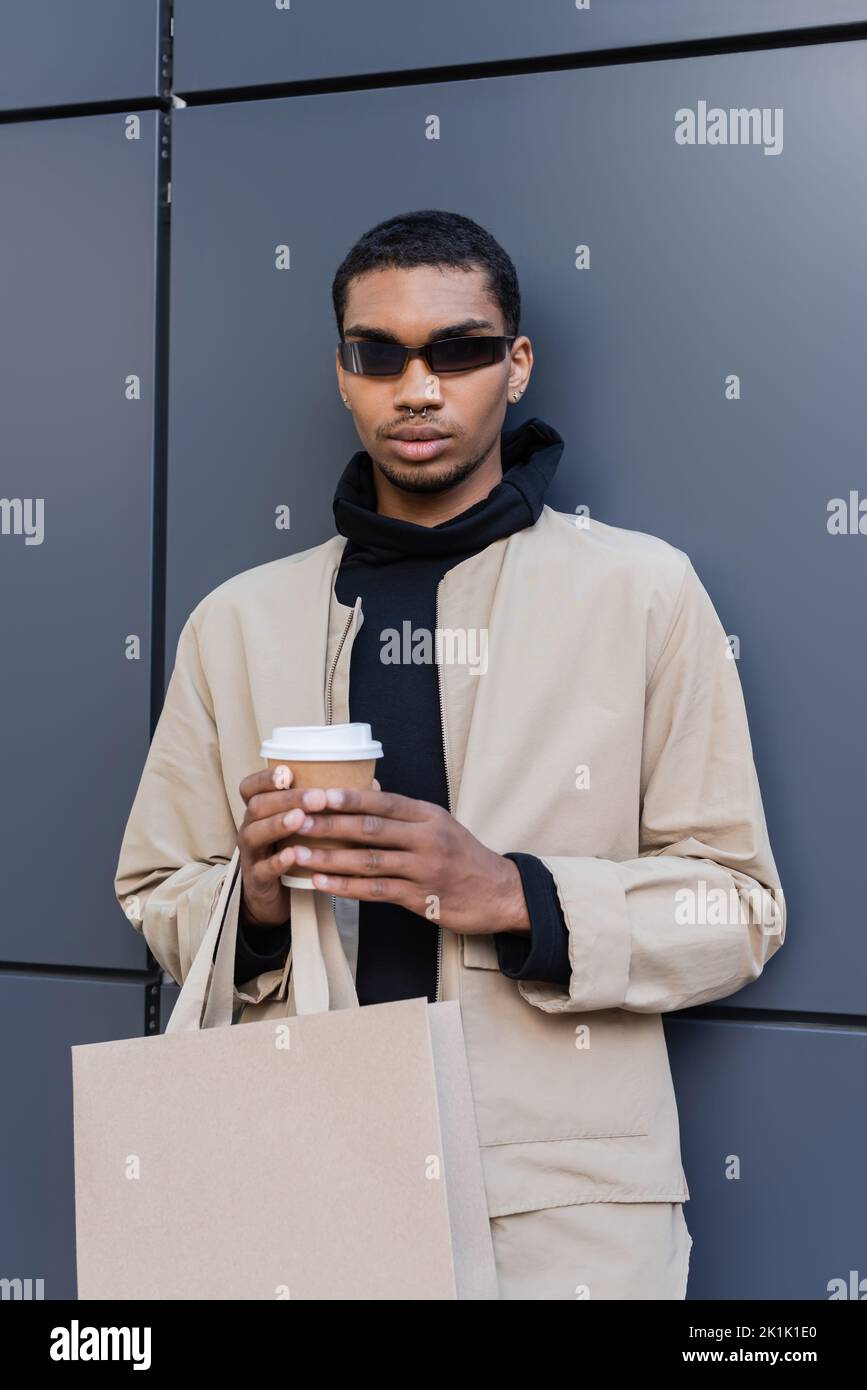 stylish african american man in sunglasses and autumnal outfit holding ...