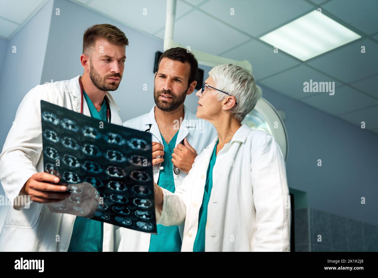 Doctors discussing patient's diagnosis looking at x-rays in a hospital ...
