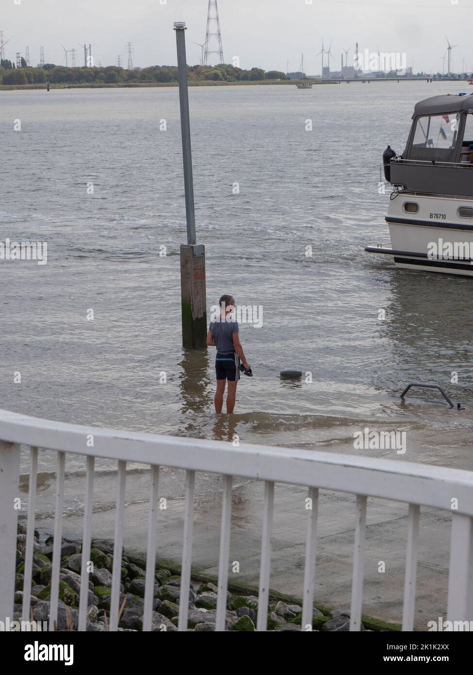 Doel, Belgium, 21 August 2022, Man stands with his feet in the water at ...