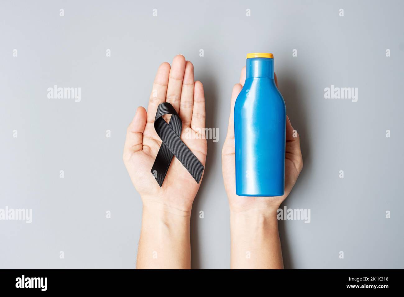 Melanoma and skin cancer awareness month. Man holding black Ribbon and ...