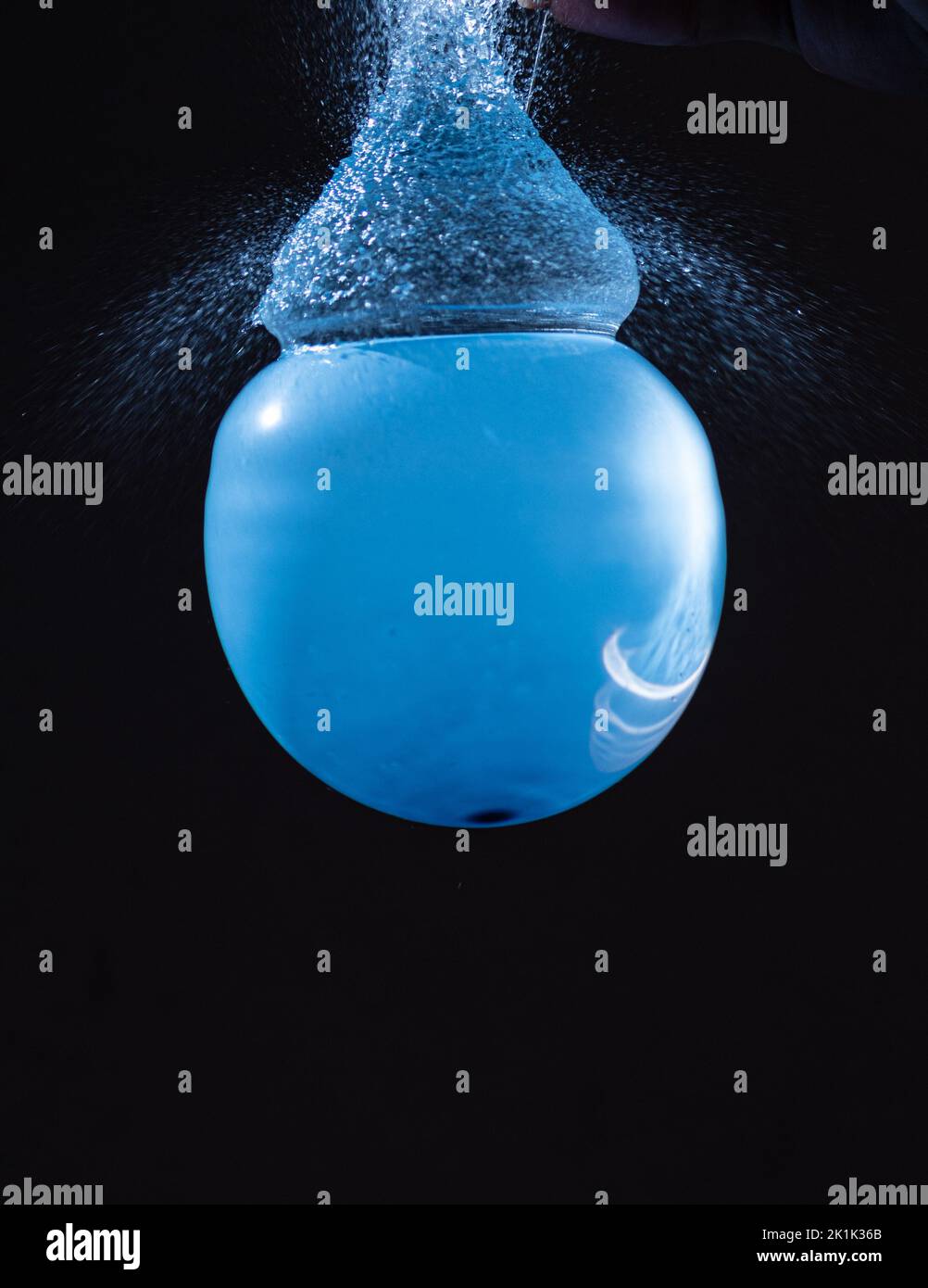 blue balloon filled with water bursting from above Stock Photo - Alamy