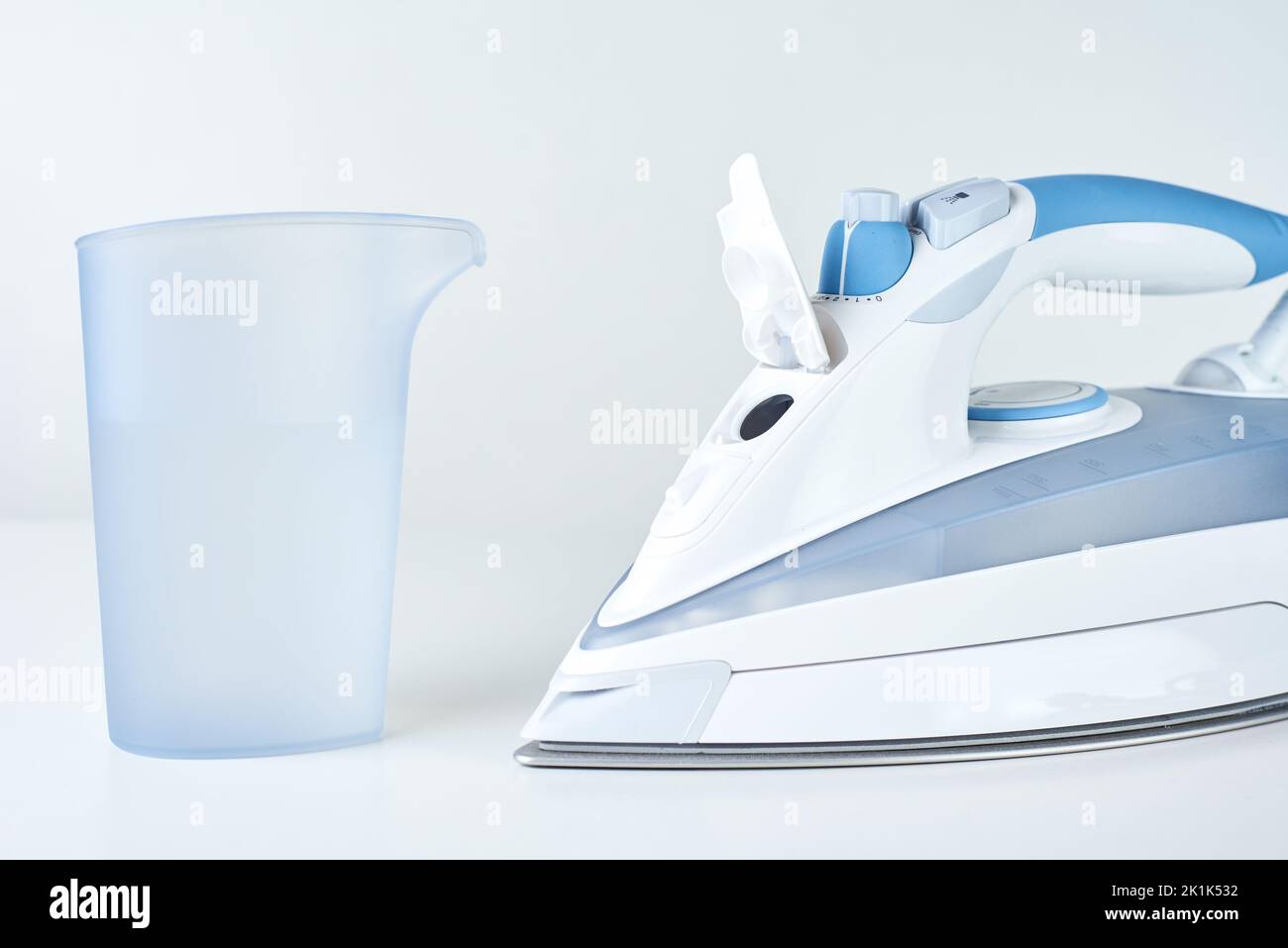 New iron and water for steam on white background, Modern household ...