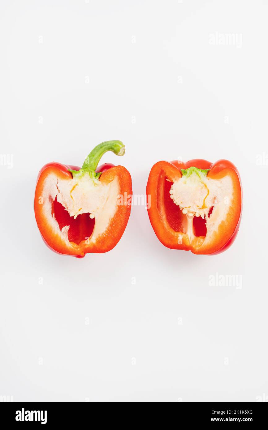 Fresh ripe sweet red bell pepper cut in half on white background ...
