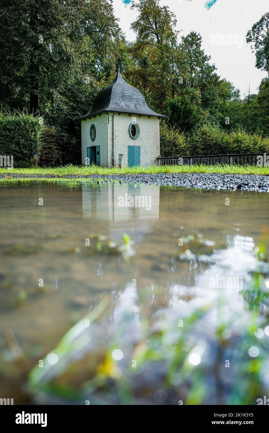 Small chinese inspired pavilion in park reflected in puddle Stock Photo ...