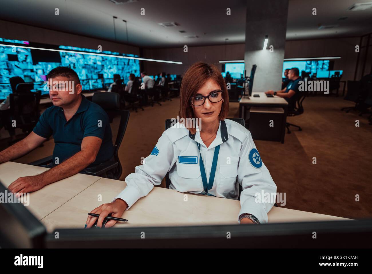 Female security operator working in a data system control room offices ...
