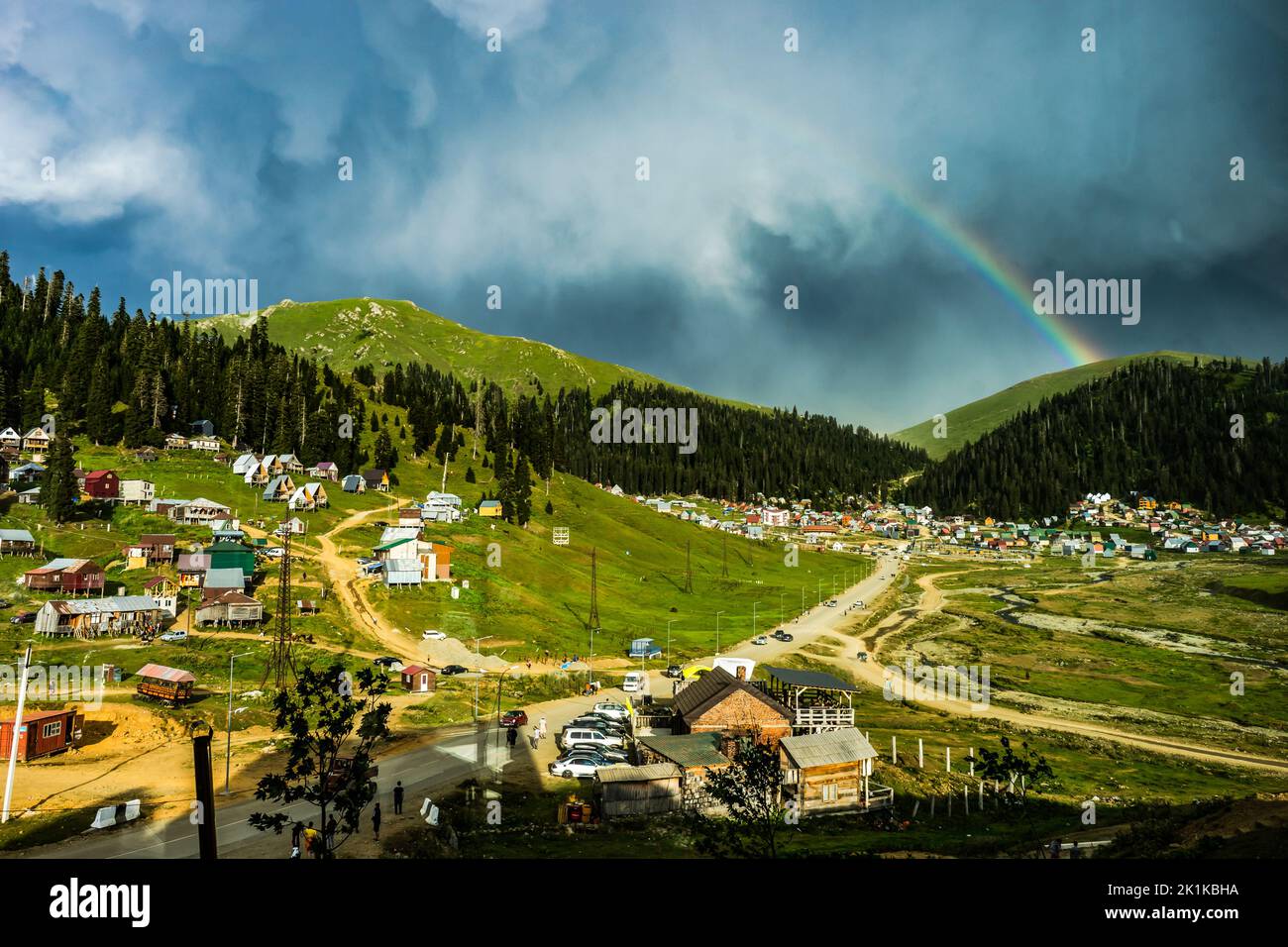 Aerial view of traditional village houses and rainbow over the Caucasus ...