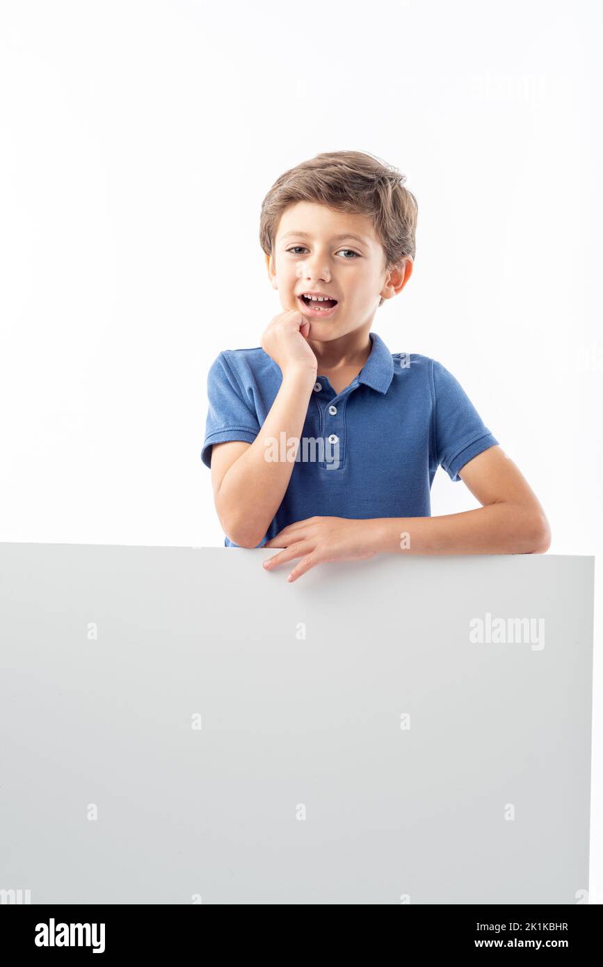 Smiling Caucasian boy showing a white advertising poster with space for ...