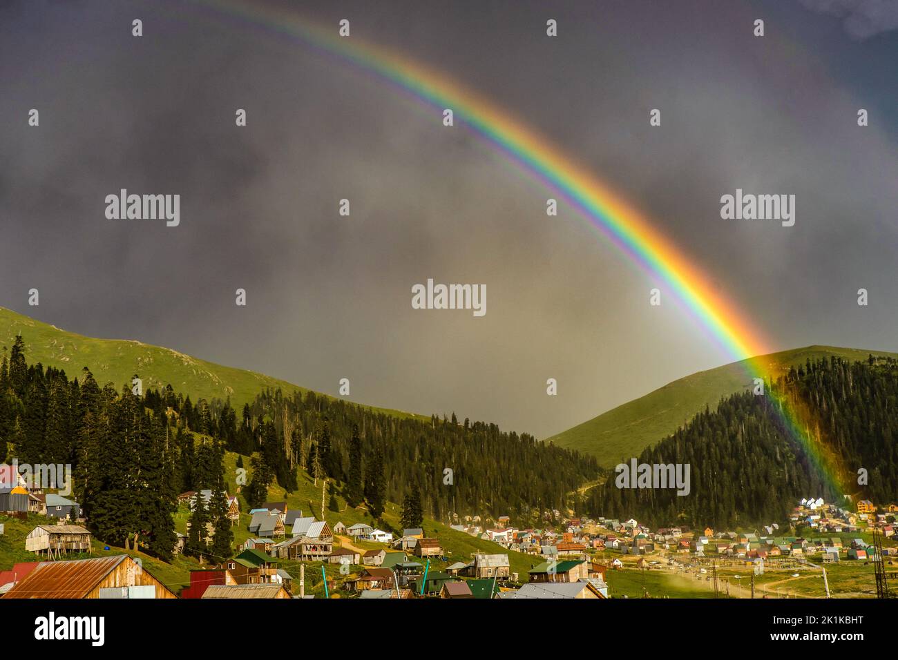 Aerial view of traditional village houses and rainbow over the Caucasus ...