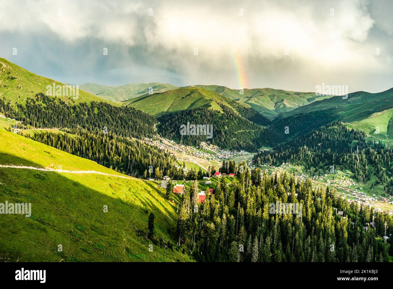 Aerial view of traditional village houses and a rainbow in mountains ...
