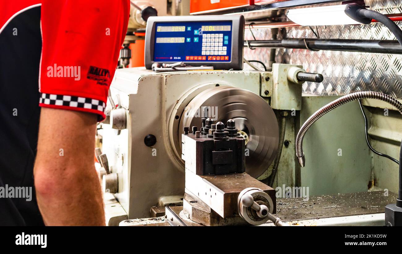A portrait of a full force racing component operating a lathe Stock ...