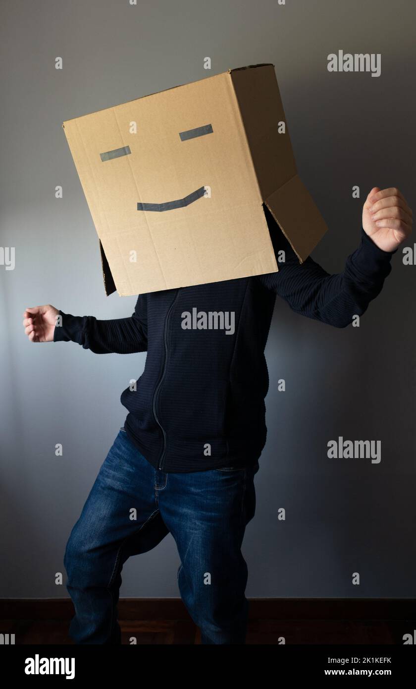 Smiling man with a cardboard box on his head dancing Stock Photo - Alamy