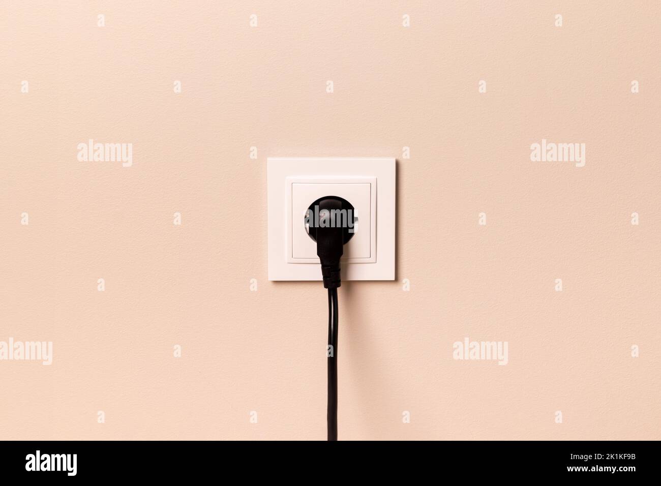 White european electrical outlet with black plug inserted into it on ...