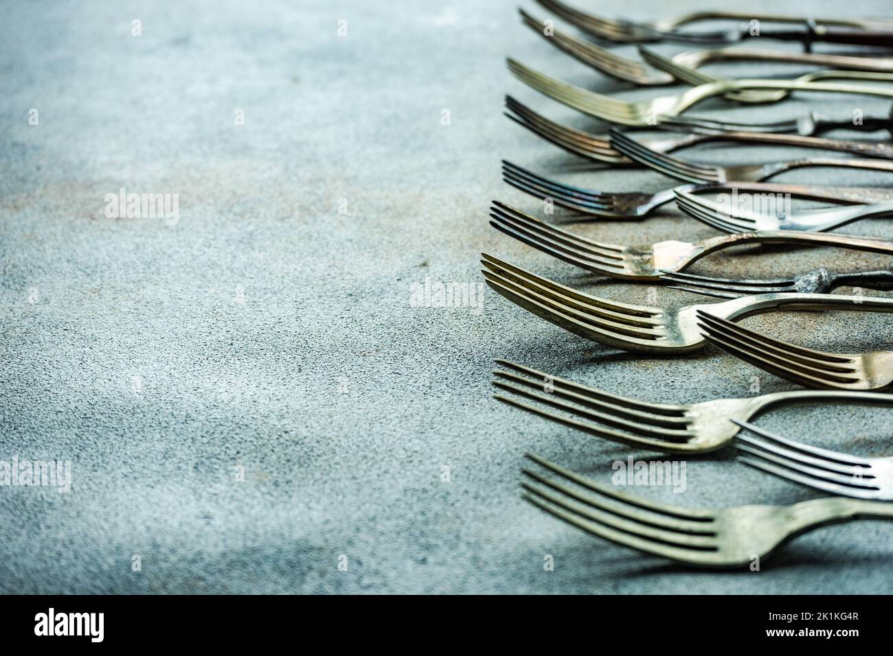 Close-Up of a row of assorted vintage forks on a table Stock Photo - Alamy