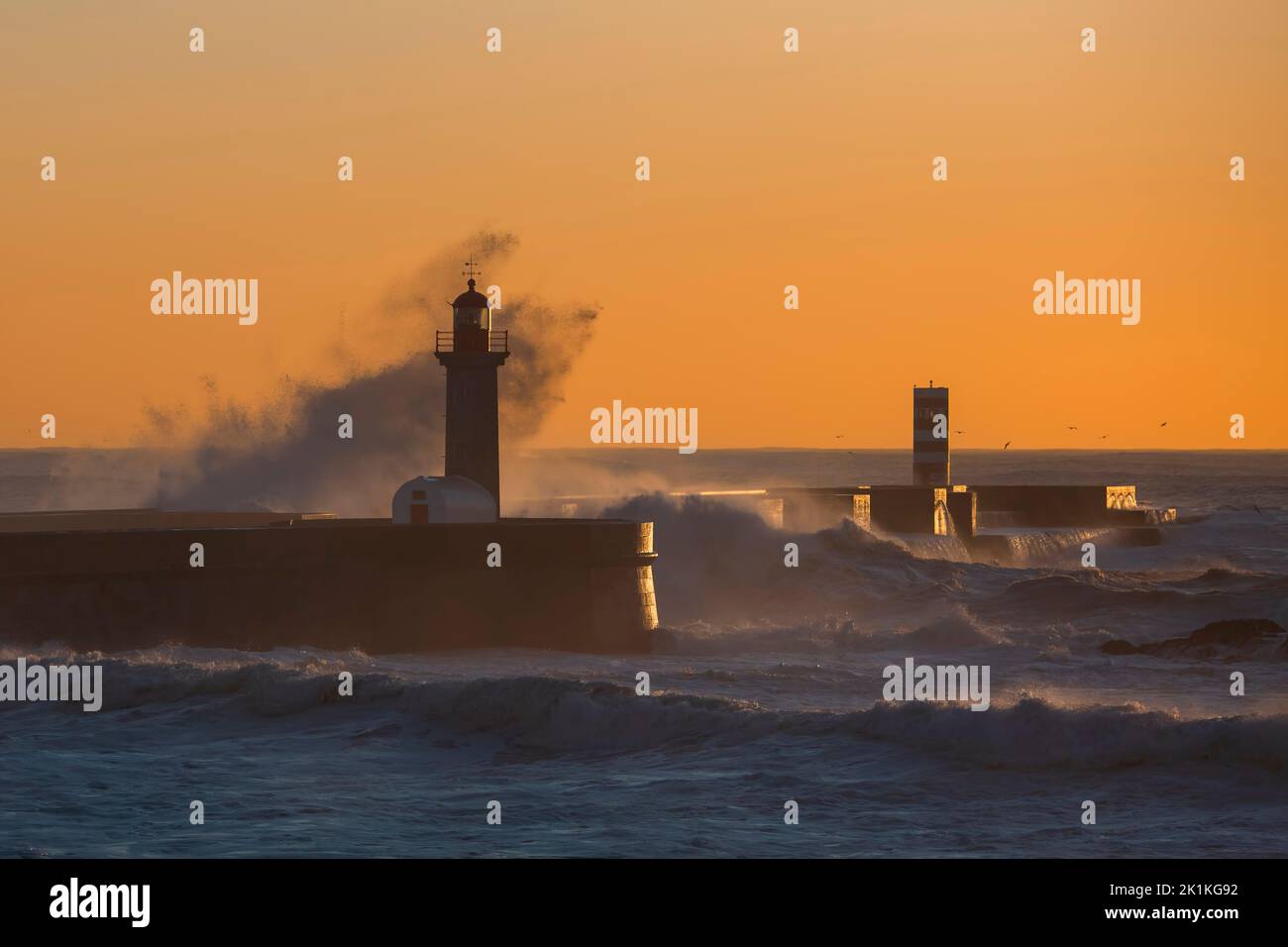 View of a lighthouse, washed in the twilight by a wave. Porto, Portugal ...