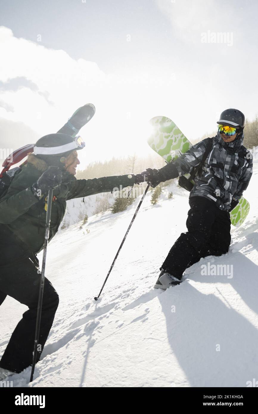 Couple holding hands climbing mountain hi-res stock photography and ...