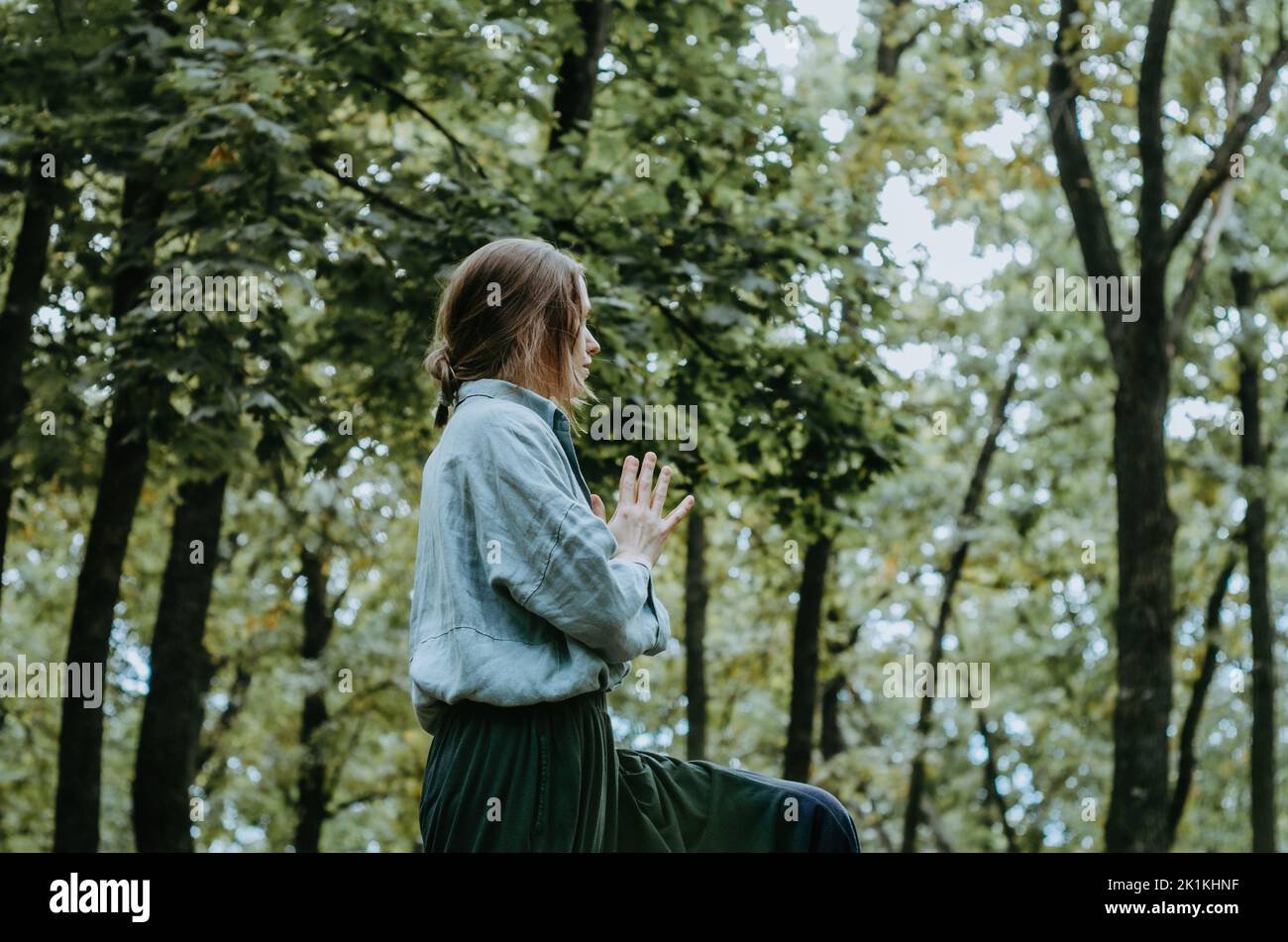 Woman in early fall forest with namaste prayer hands at chest Stock ...