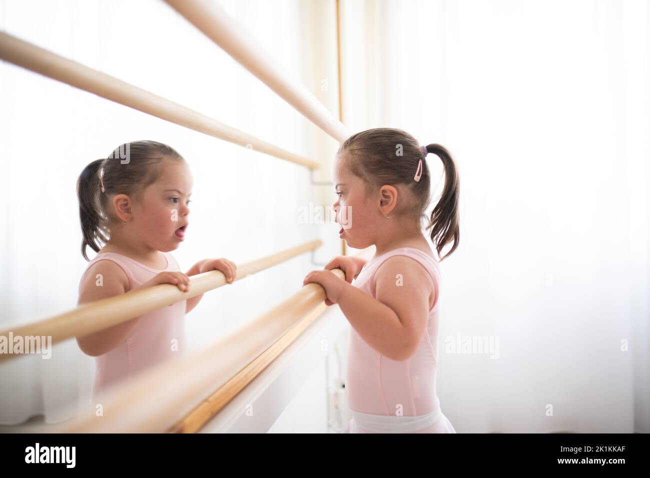 Little girl with down syndrome at ballet class in dance studio ...