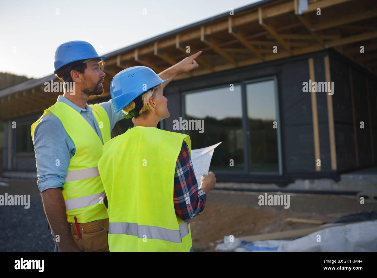 Construction engineers or architects with blueprints checking eco ...