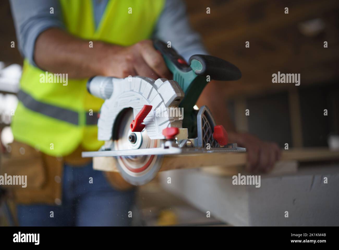 Close-up of construction worker working with eletric saw inside wooden ...
