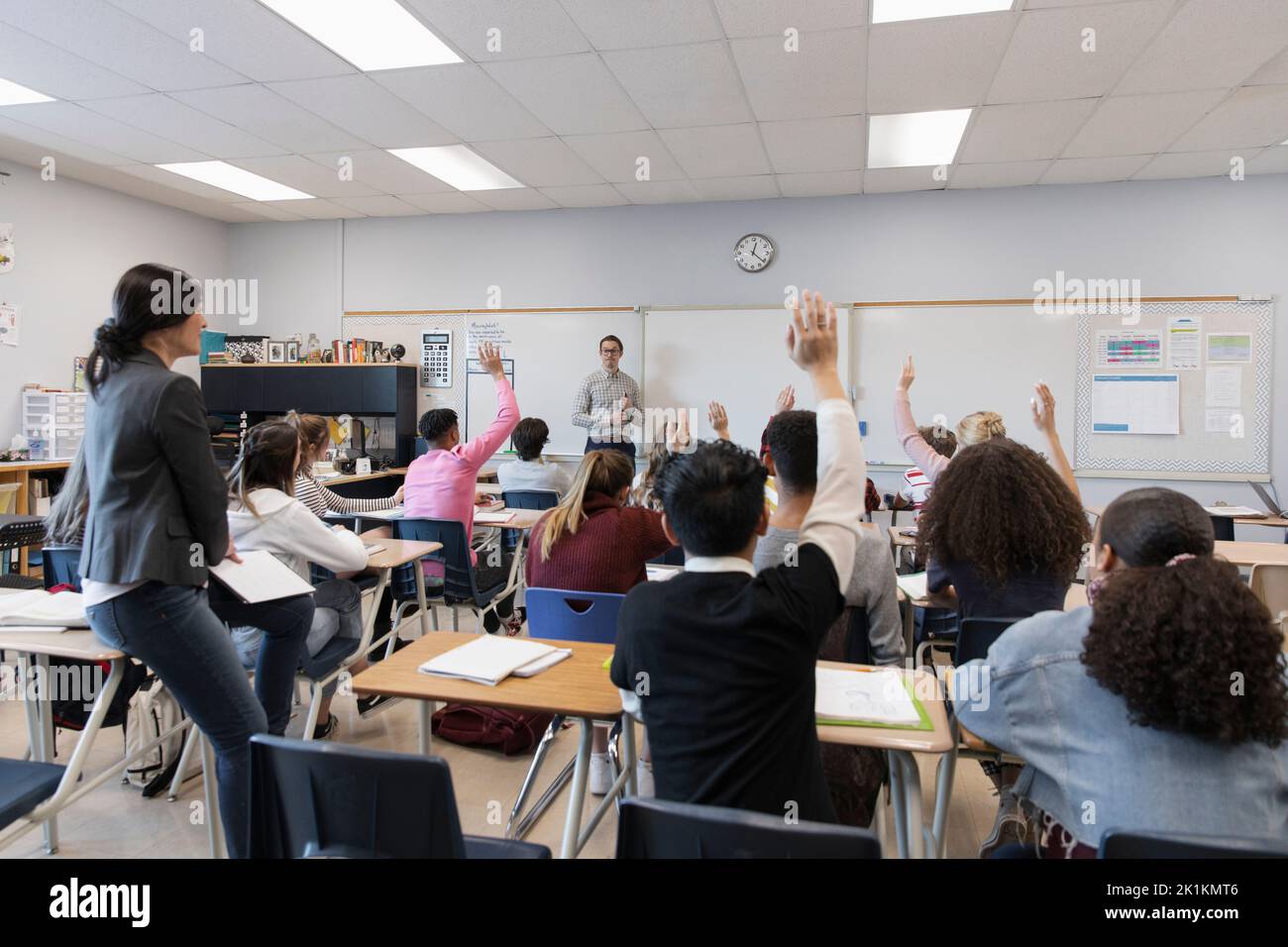 High School Students In Classroom Raising Hands