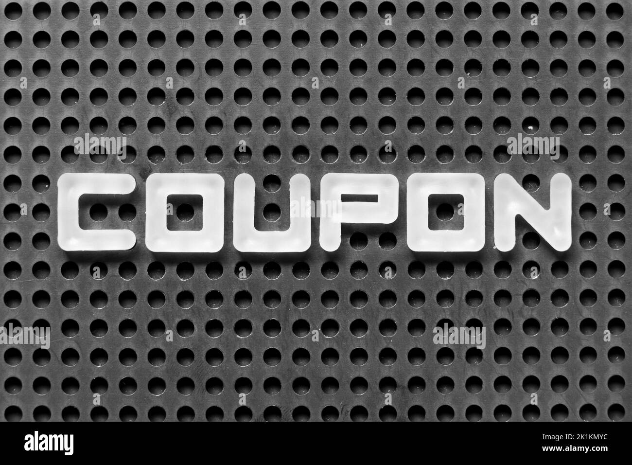 White alphabet letter in word coupon on black pegboard background Stock ...
