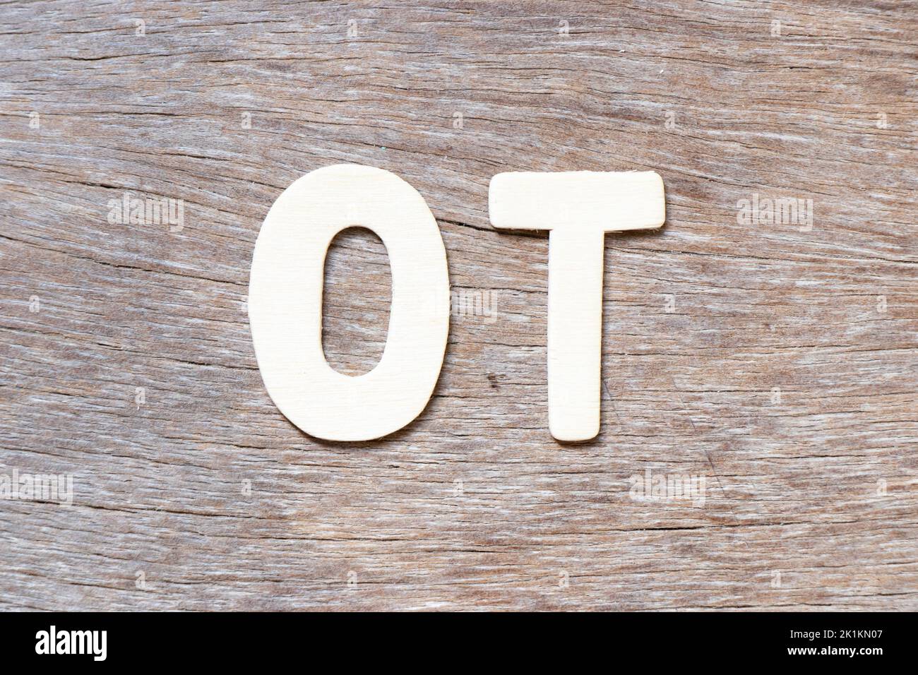 Alphabet letter in word OT (abbreviation for overtime) on wood ...
