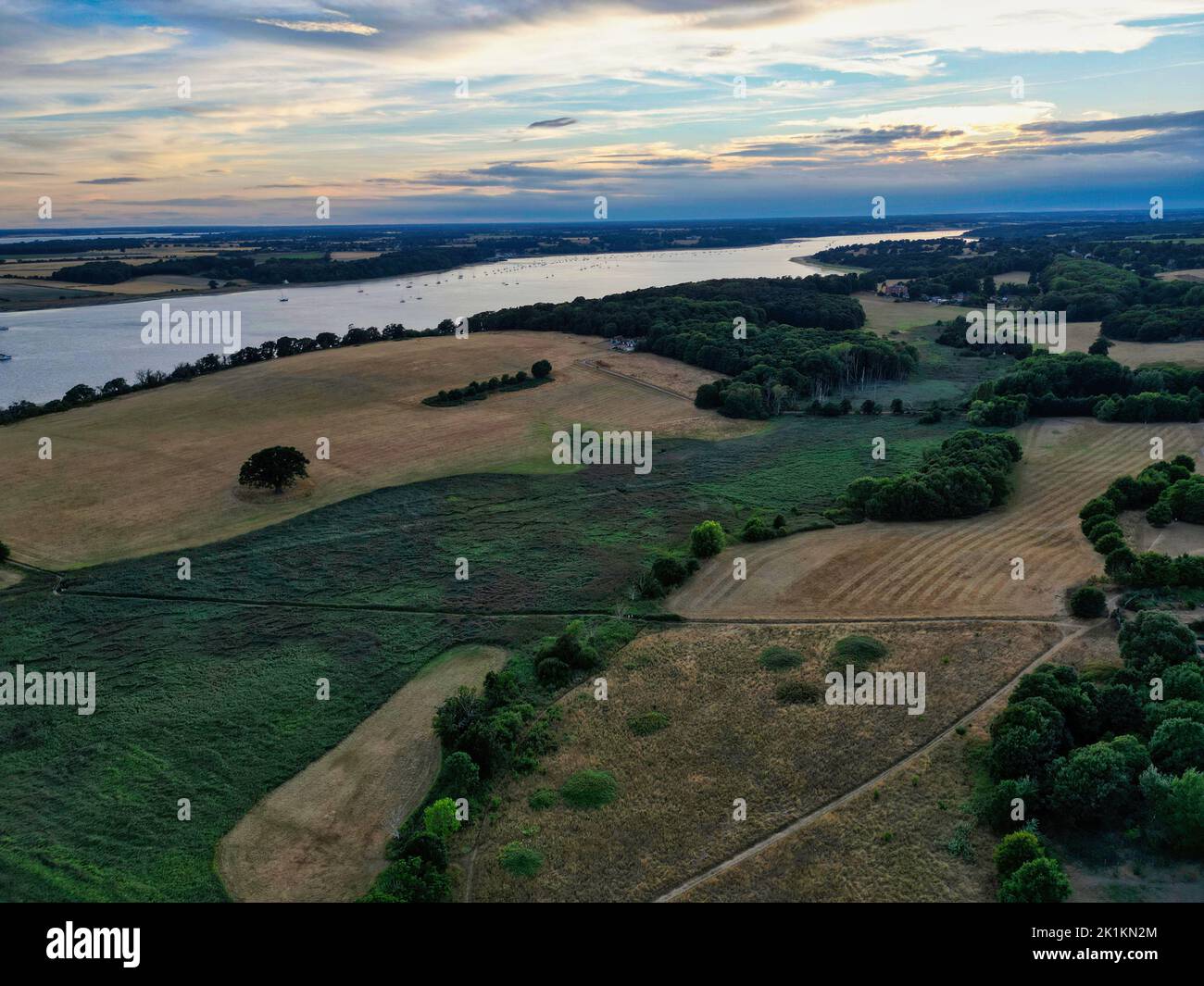 The aerial view of Orwell river and fields under the blue sunset sky in ...