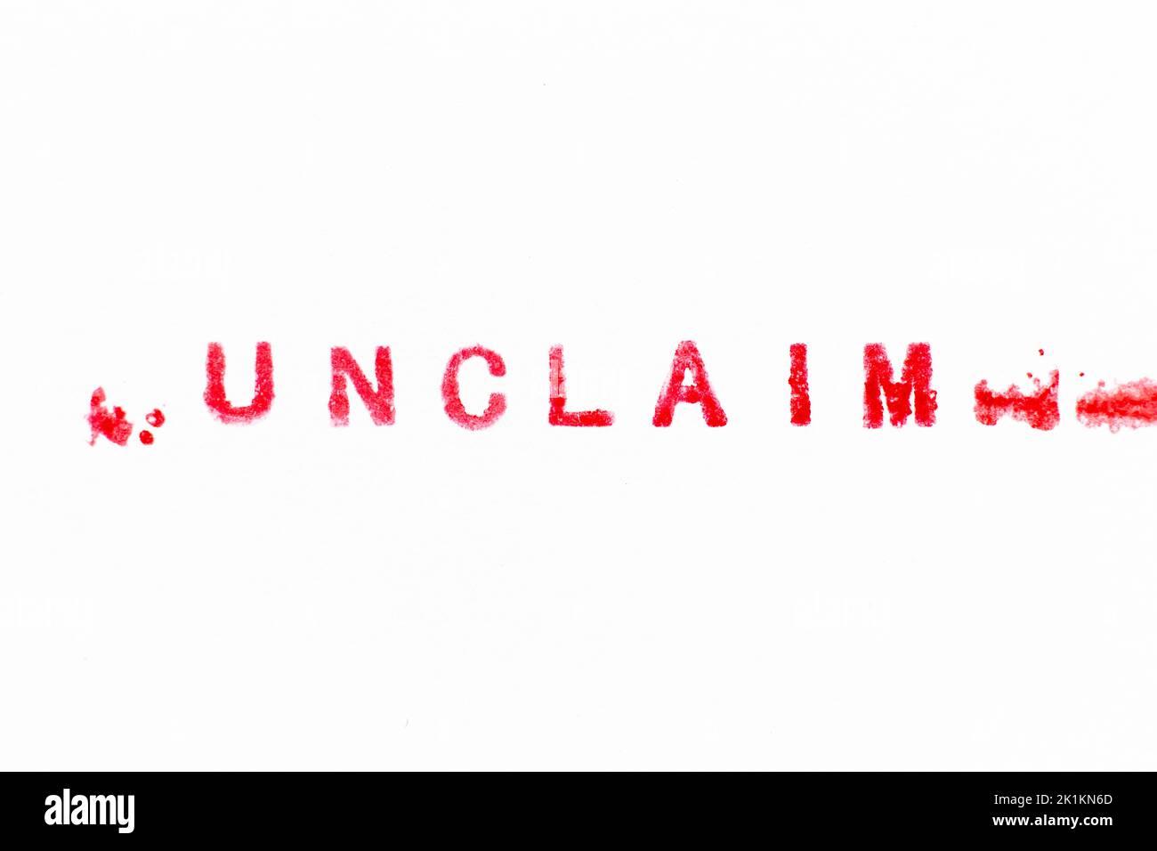 Red color ink rubber stamp in word unclaim on white paper background ...