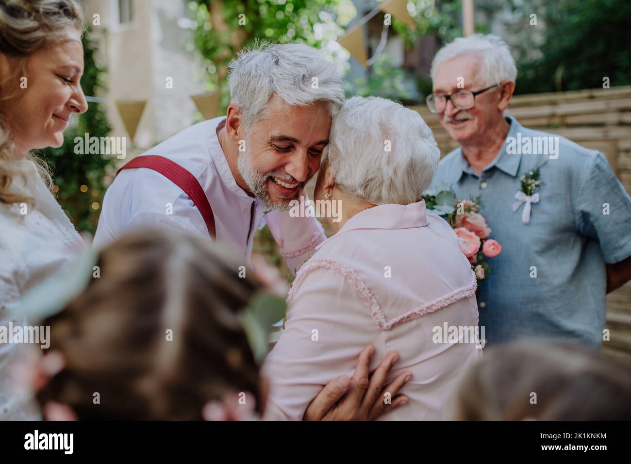 Mature bride and groom receiving congratulations at wedding reception ...
