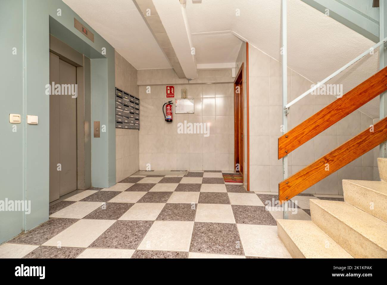Landing between floors of a building with terrazzo stairs and elevator ...