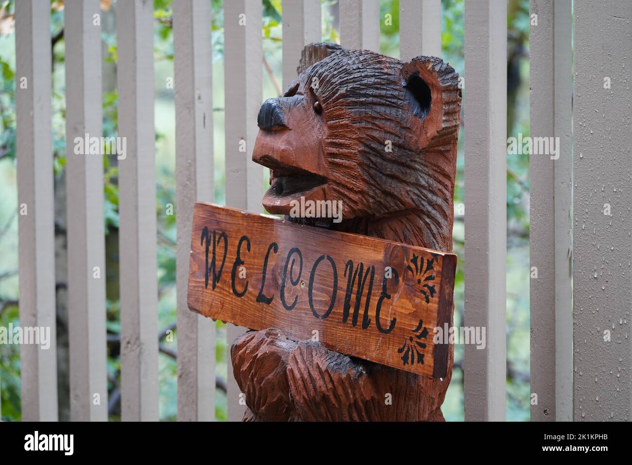 A wooden bear sculpture holding a welcome sign Stock Photo - Alamy