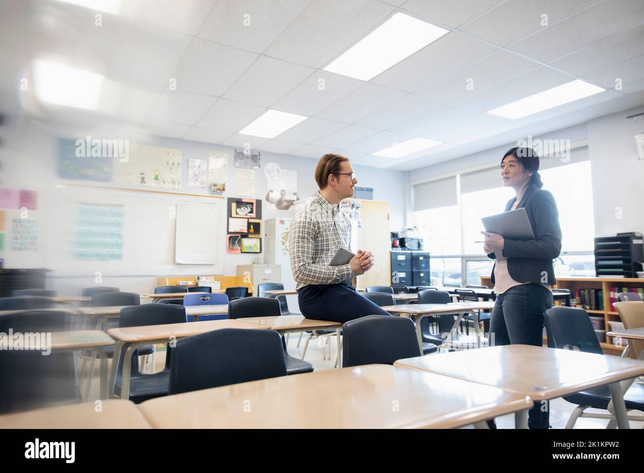 High school teachers with digital tablets talking in classroom Stock ...
