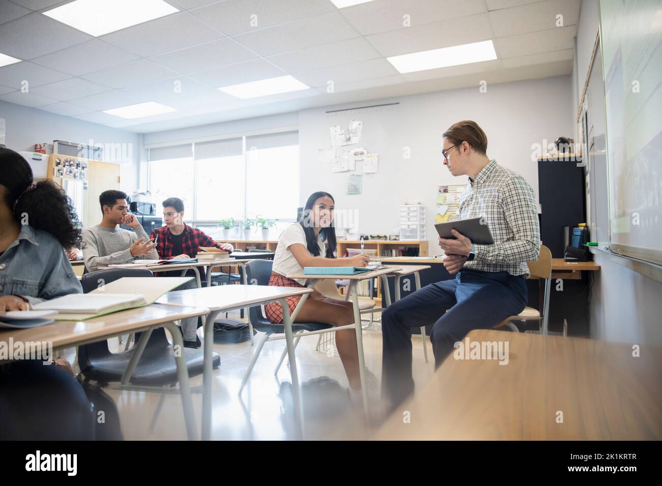 Teenage students and teacher desk hi-res stock photography and images ...