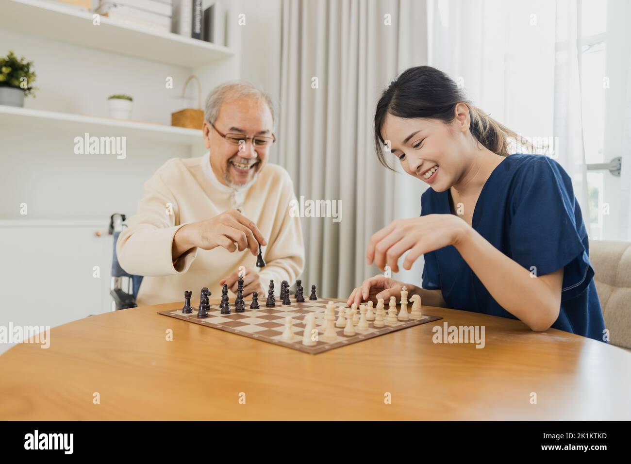 Asian nurse, doctor woman assisting take care and play chess with ...