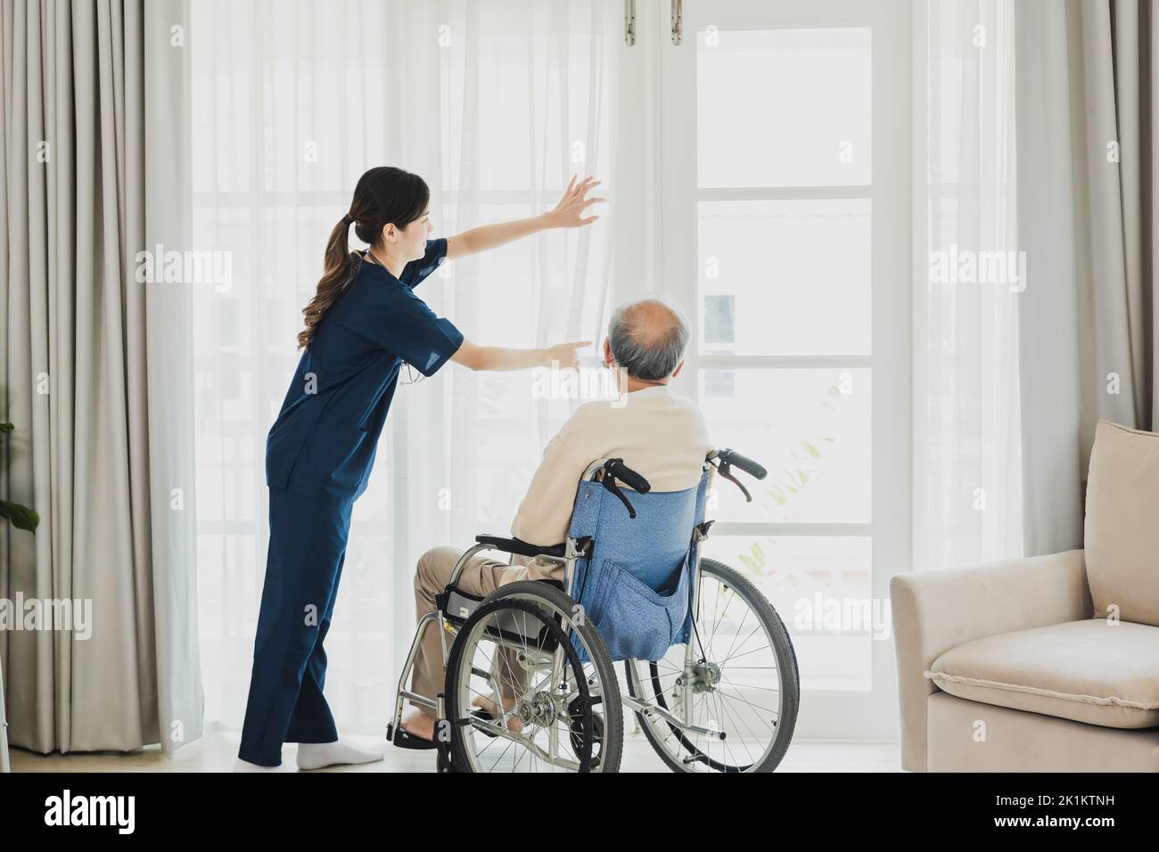 Senior Asian man in wheelchair receives medical help for injury, take ...